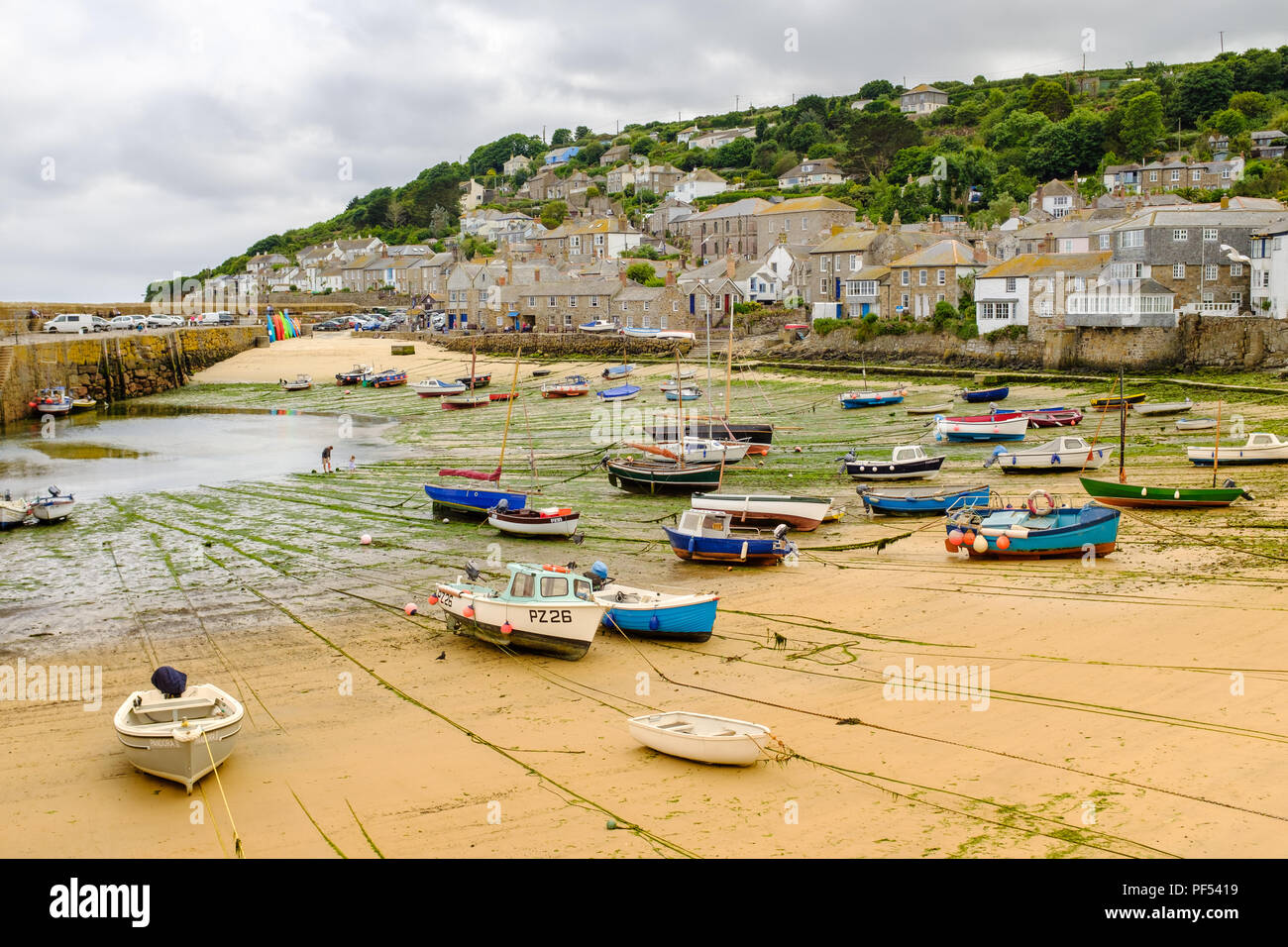 MOUSEHOLE, ENGLAND - JUNE 20: Fishing boats at low tide within ...