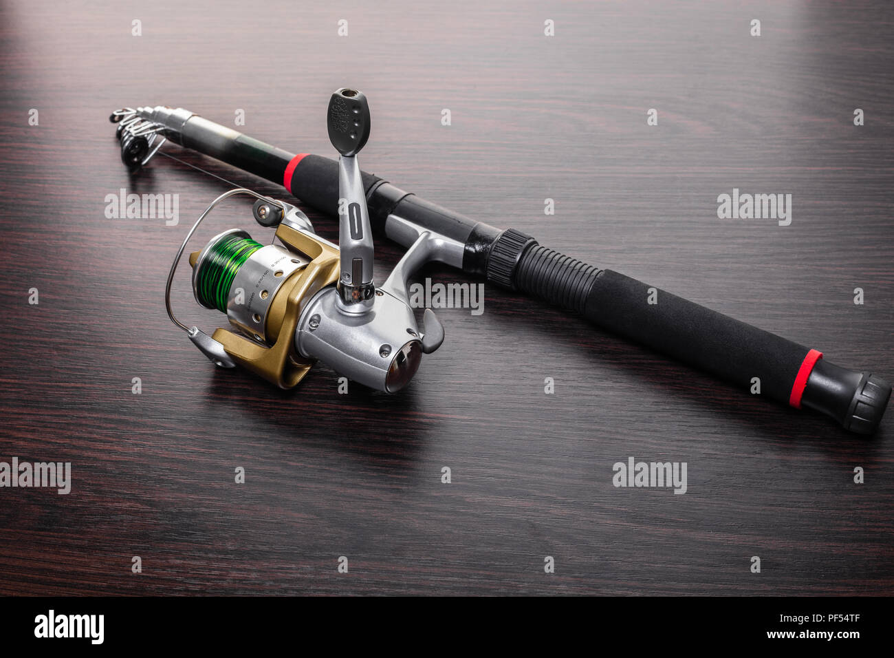 fishing rod with a coil on wooden background Stock Photo - Alamy