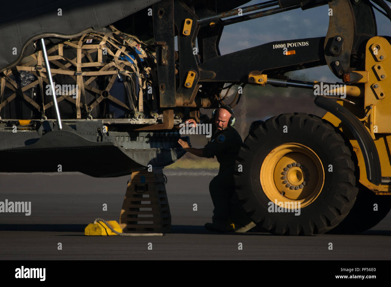 A U.S. Air Force loadmaster assigned to the 120th Airlift Wing helps ...