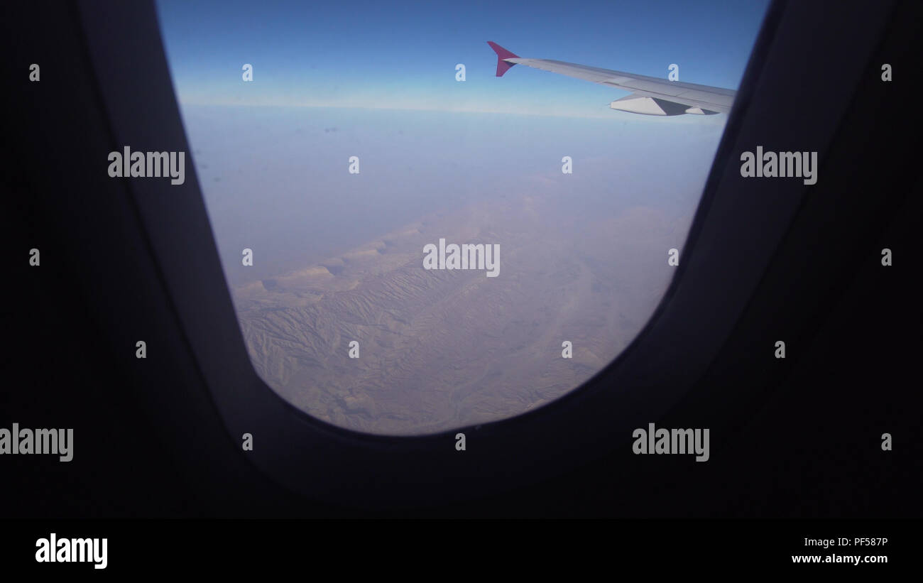 Mountain range from the airplane window. Airplane wing. Aerial view on ...