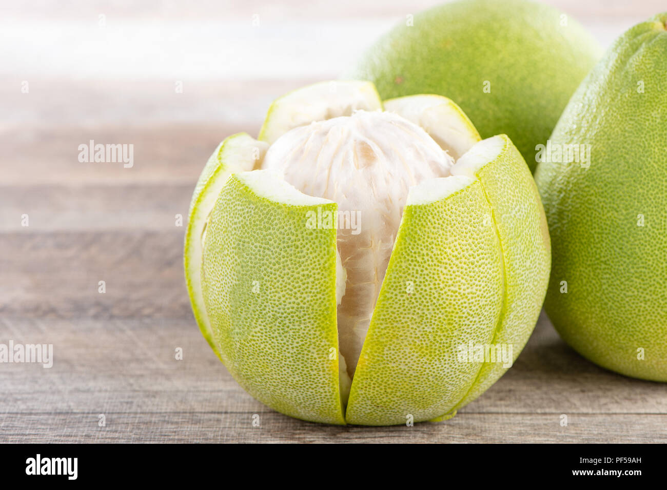fresh and peeled pomelo(shaddock), grapefruit with slices on wooden ...