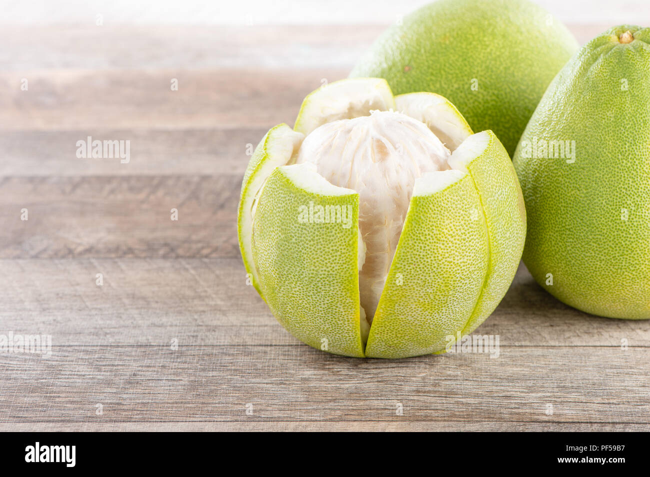fresh and peeled pomelo(shaddock), grapefruit with slices on wooden ...
