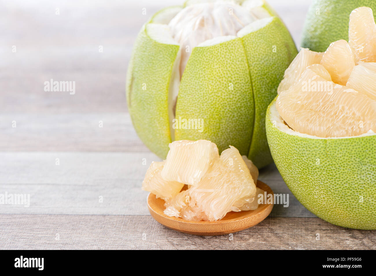 fresh and peeled pomelo(shaddock), grapefruit with slices on wooden ...