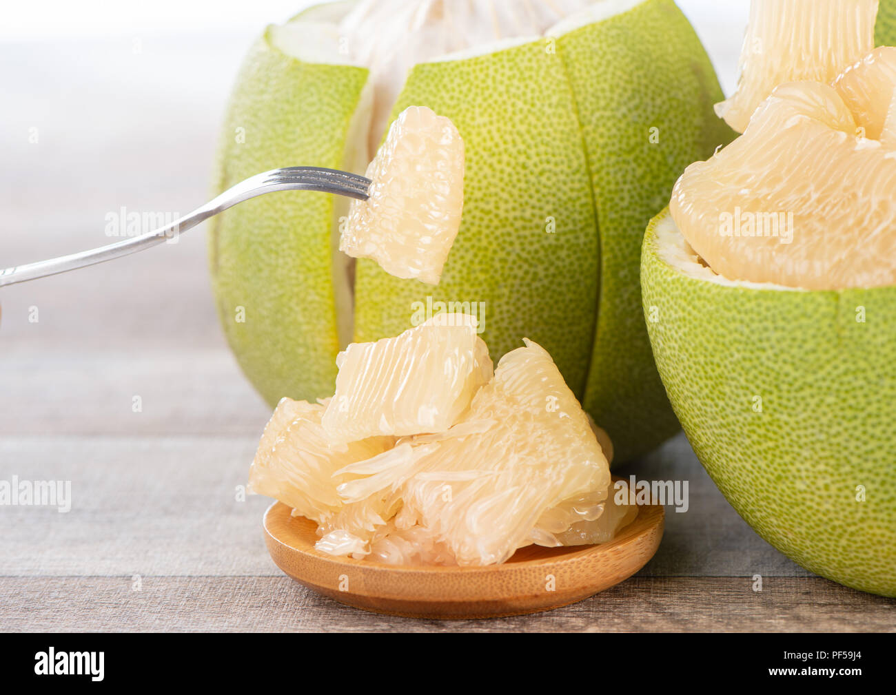 fresh and peeled pomelo(shaddock), grapefruit with slices on wooden ...