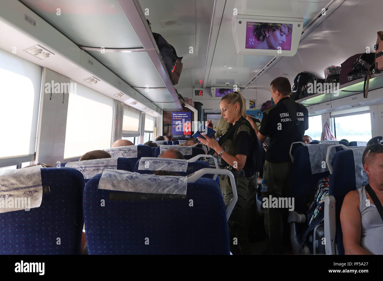 Polish border control officers checking the passports of passengers at ...