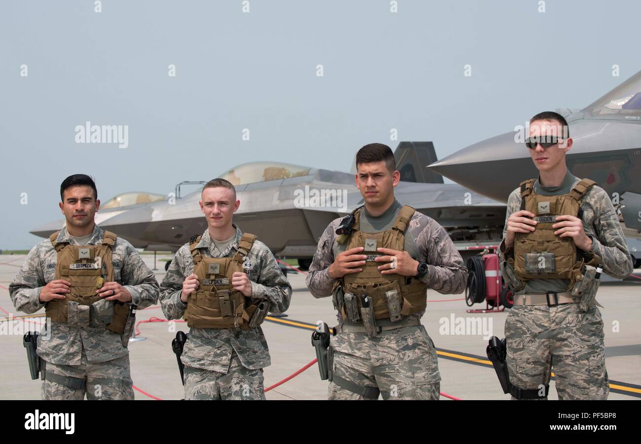 Airmen assigned to 55th Security Forces Squadron guard an F-22 Raptor ...