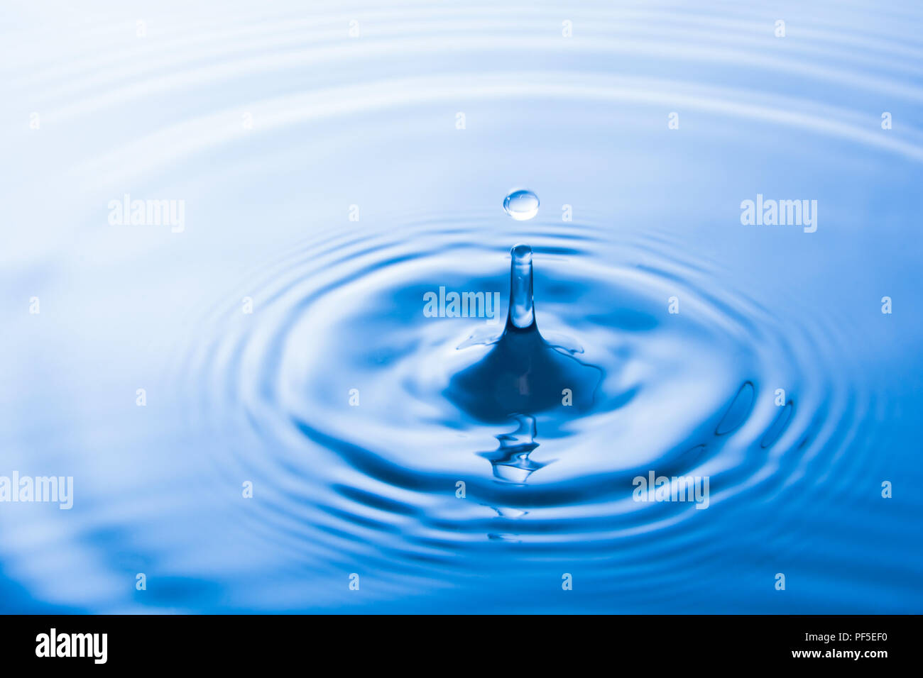 Water drop falling into water make waves. Water splash or water drop ...