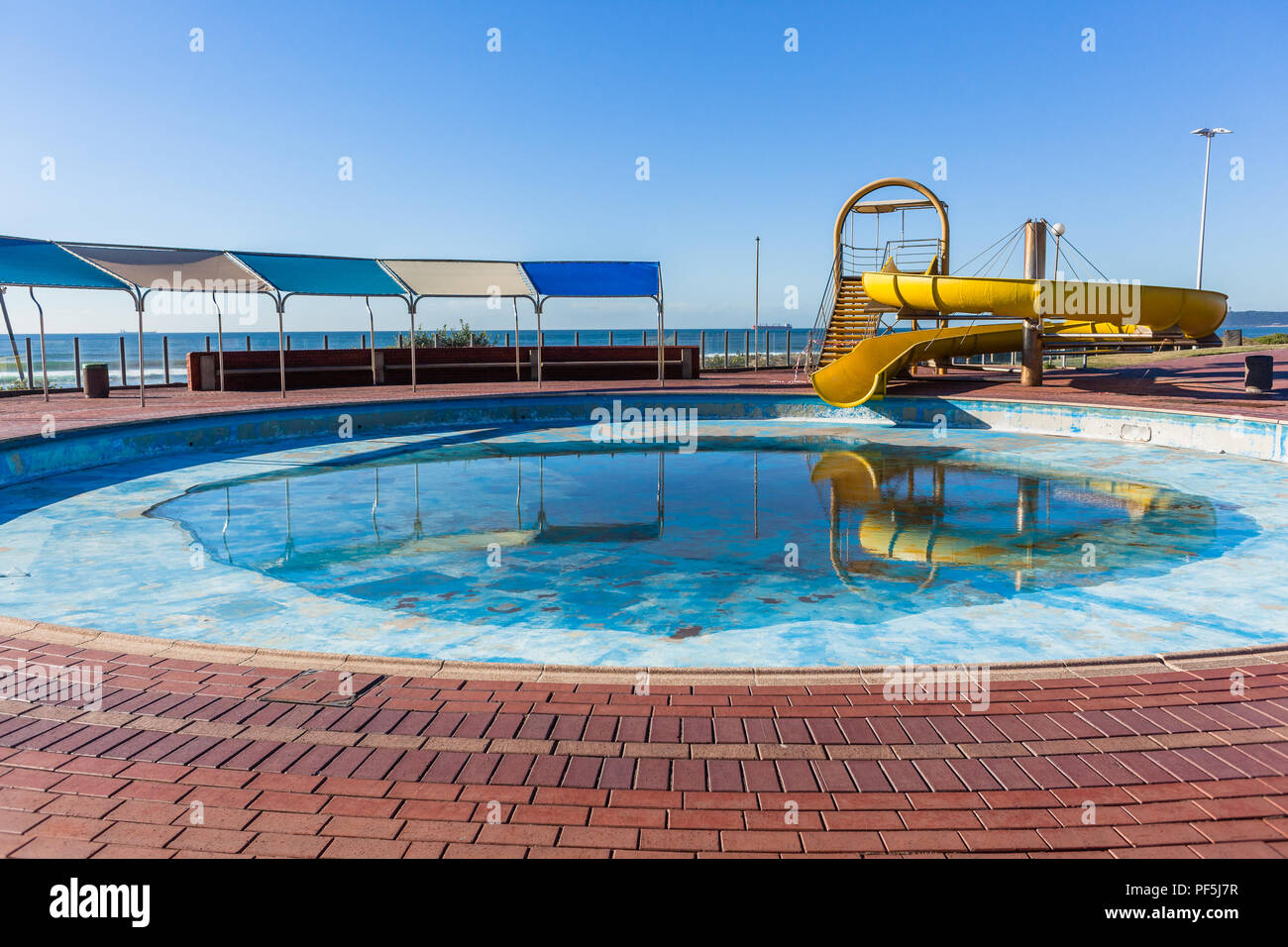 Swimming pool dry no water yellow water slide structure closeup Stock ...