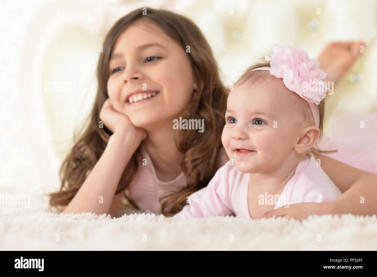 Portrait beautiful cute sisters posing in bed at home Stock Photo - Alamy