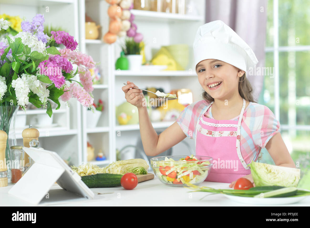 Portrait of cute little girl making dinner Stock Photo - Alamy