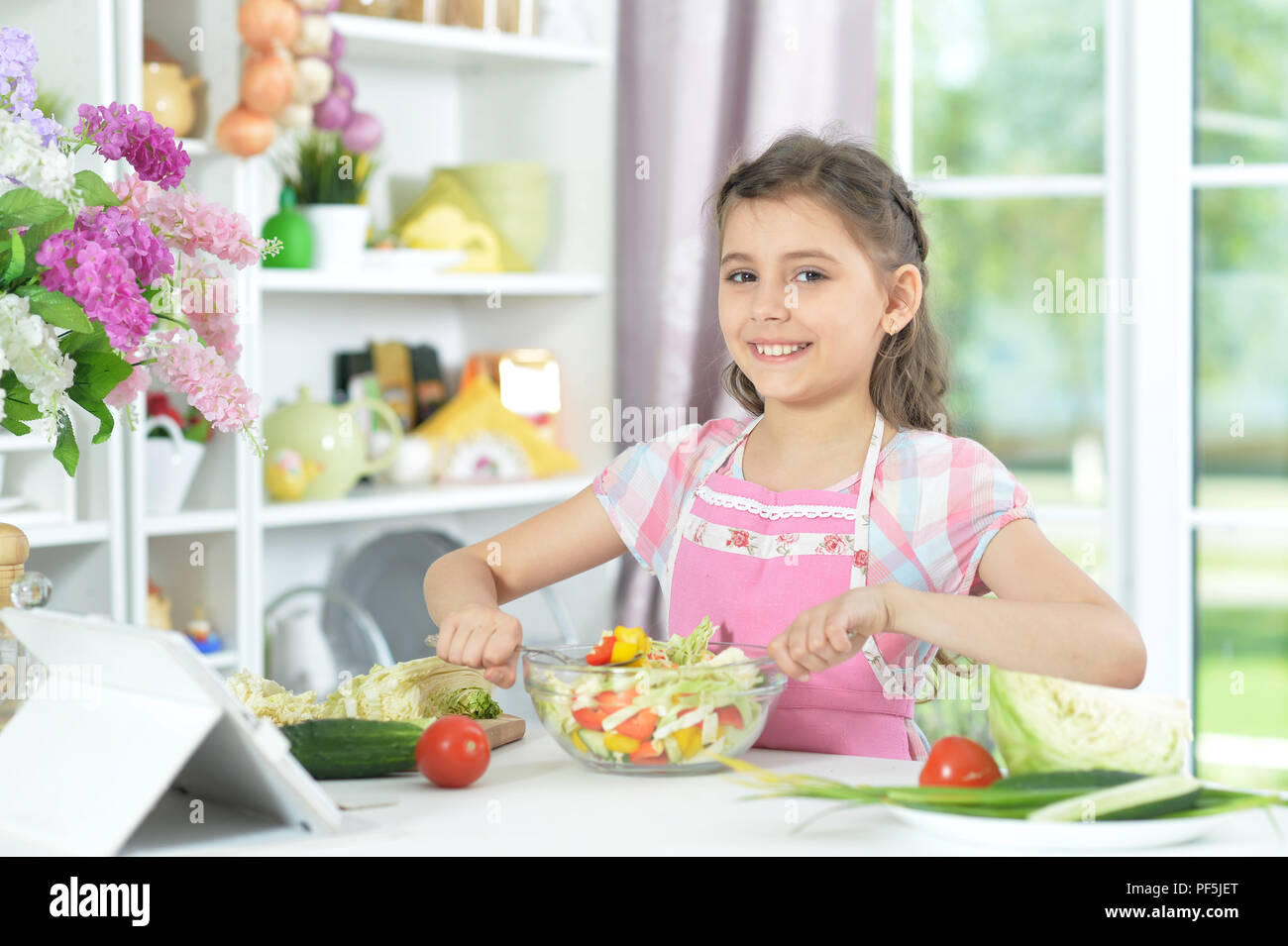 Portrait of cute little girl making dinner Stock Photo - Alamy