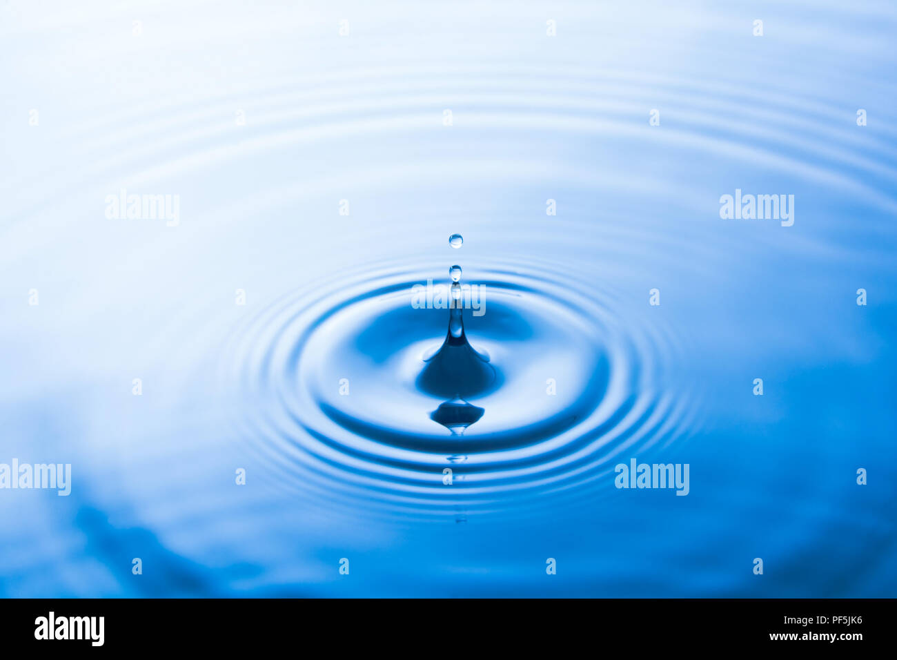 Water drop falling into water make waves. Water splash or water drop ...