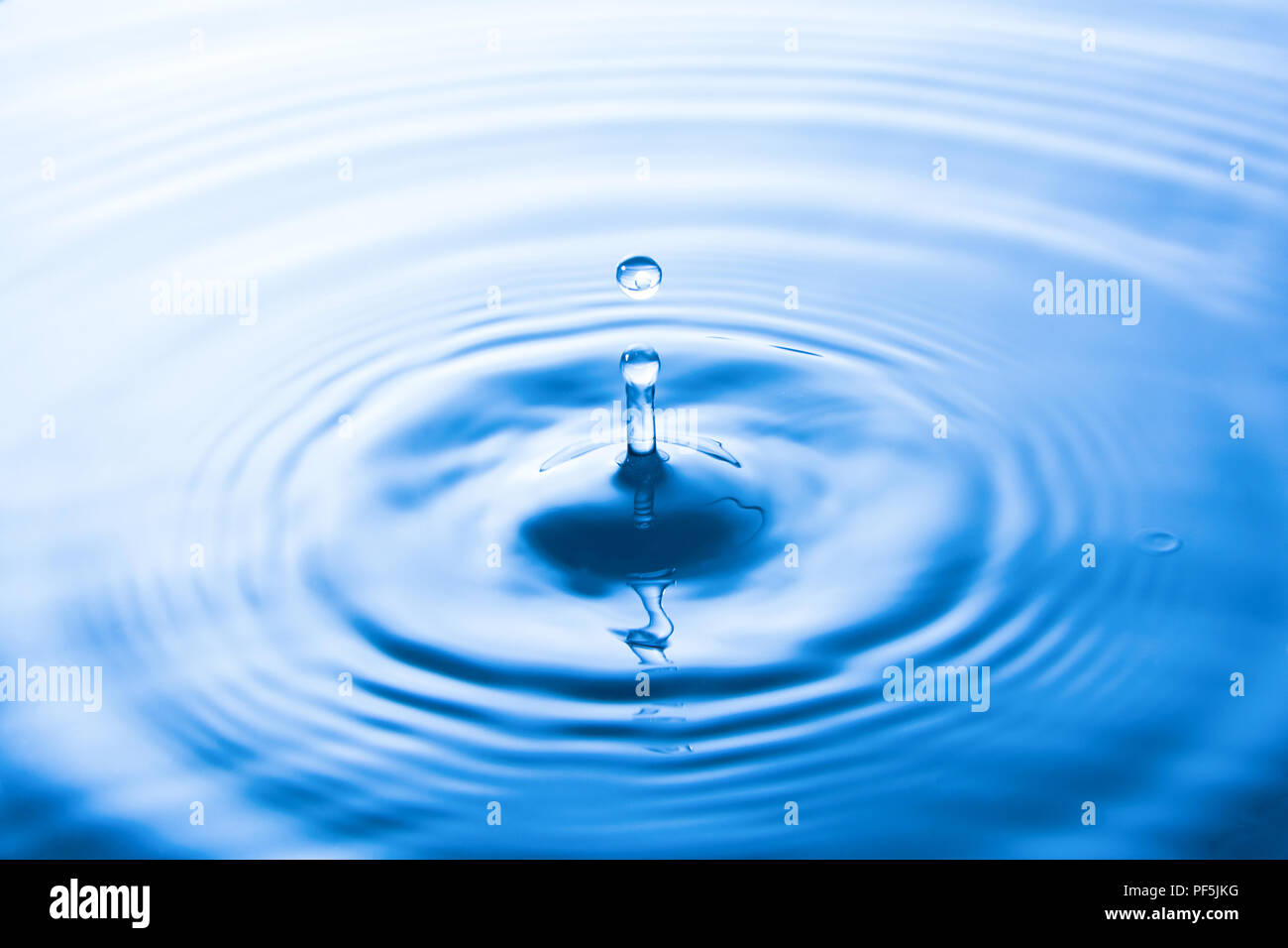 Water drop falling into water make waves. Water splash or water drop ...