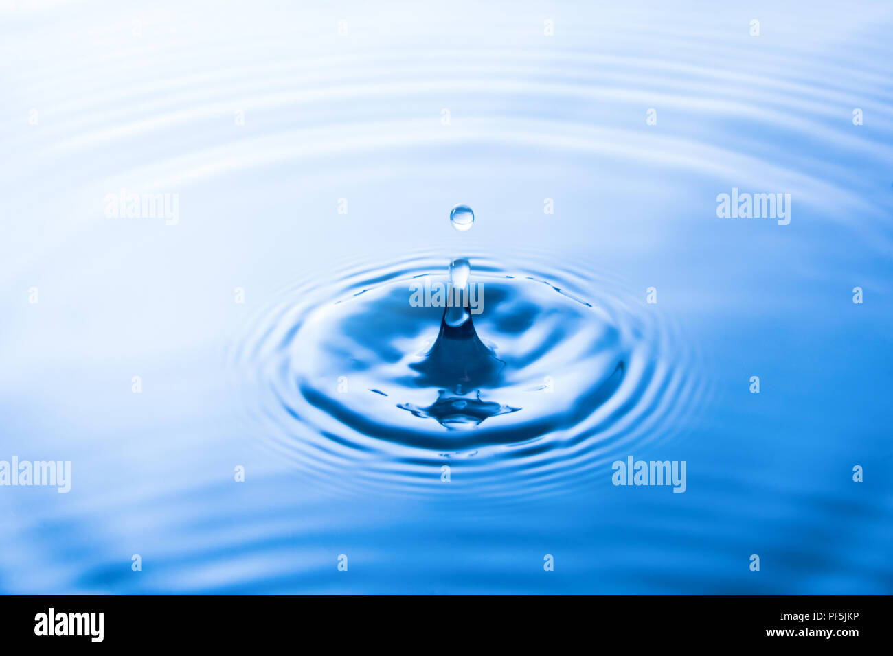 Water drop falling into water make waves. Water splash or water drop ...