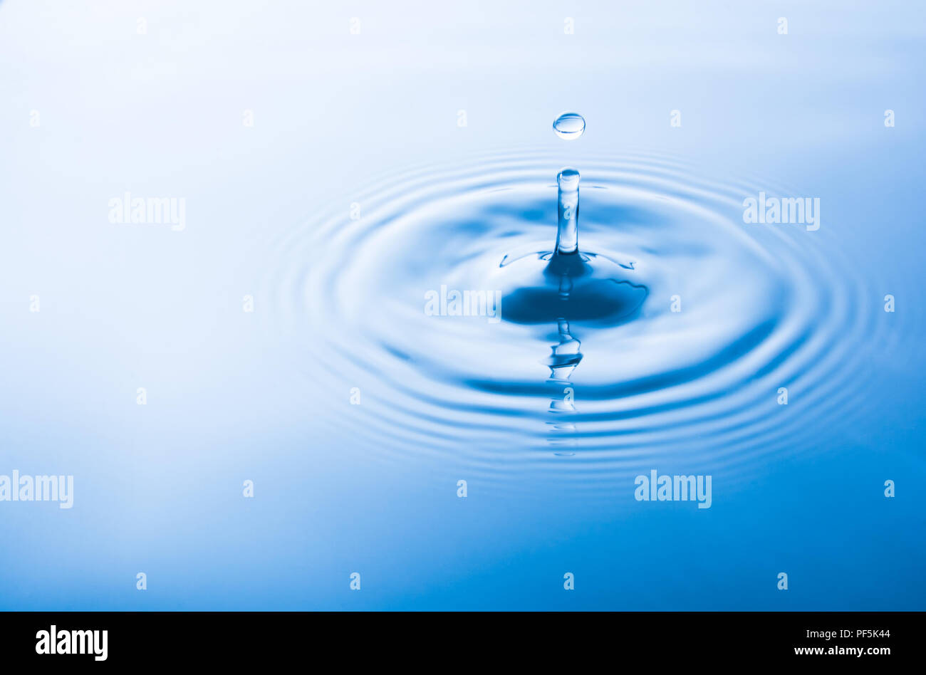 Water drop falling into water make waves. Water splash or water drop ...