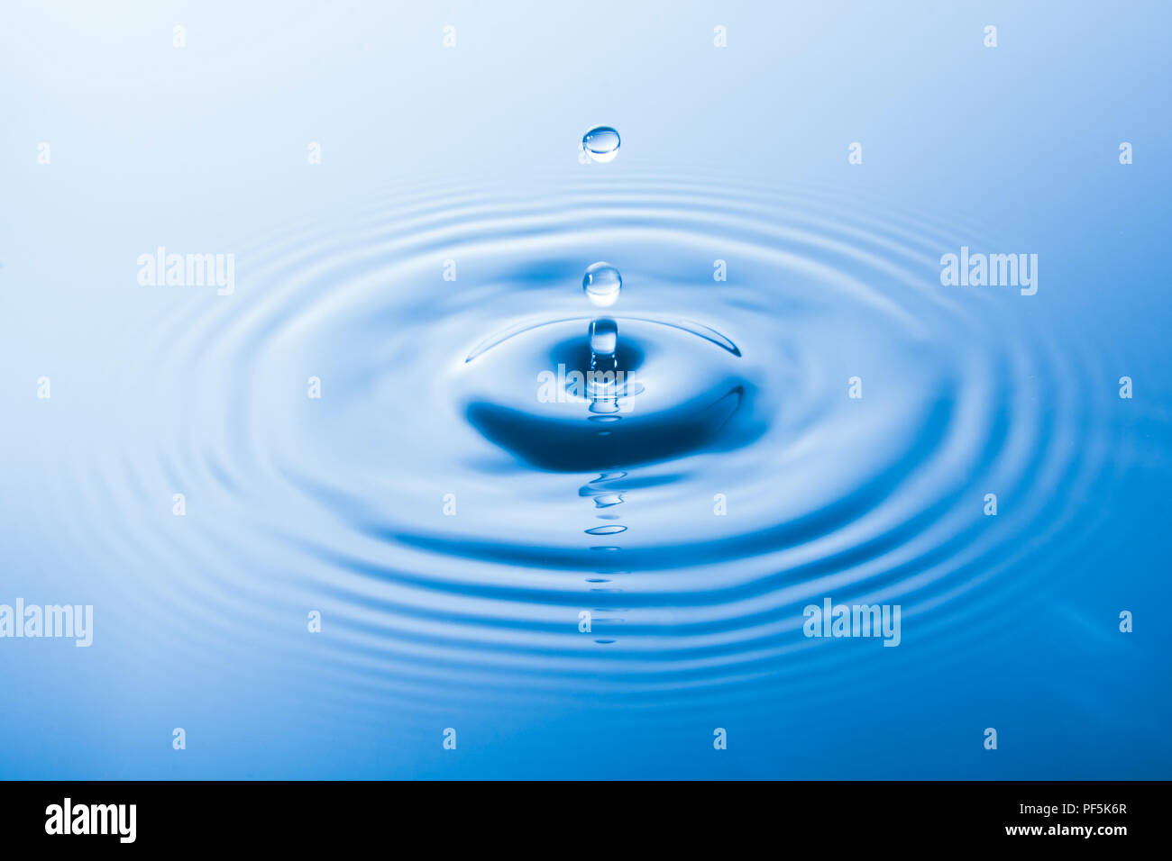 Water drop falling into water make waves. Water splash or water drop ...