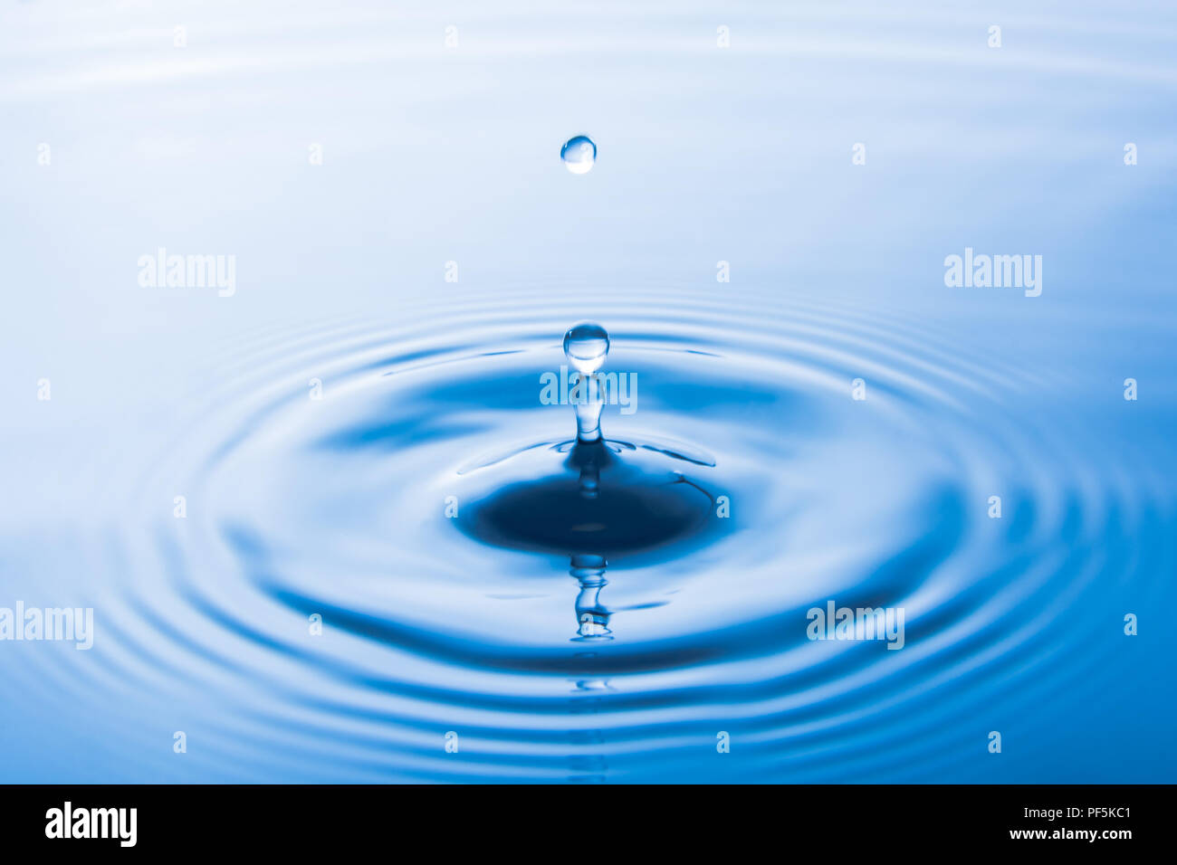 Water drop falling into water make waves. Water splash or water drop ...