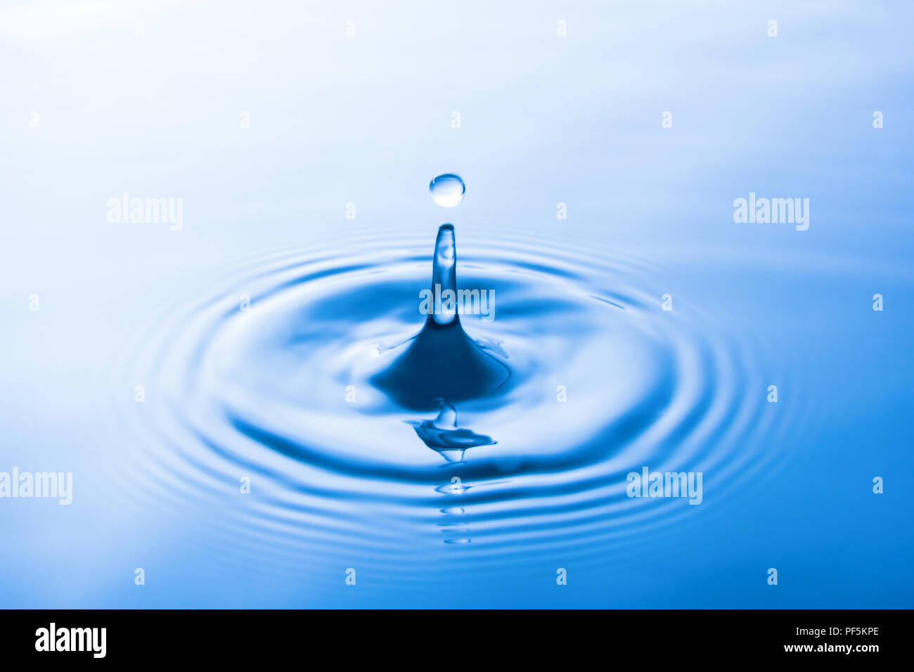 Water drop falling into water make waves. Water splash or water drop ...