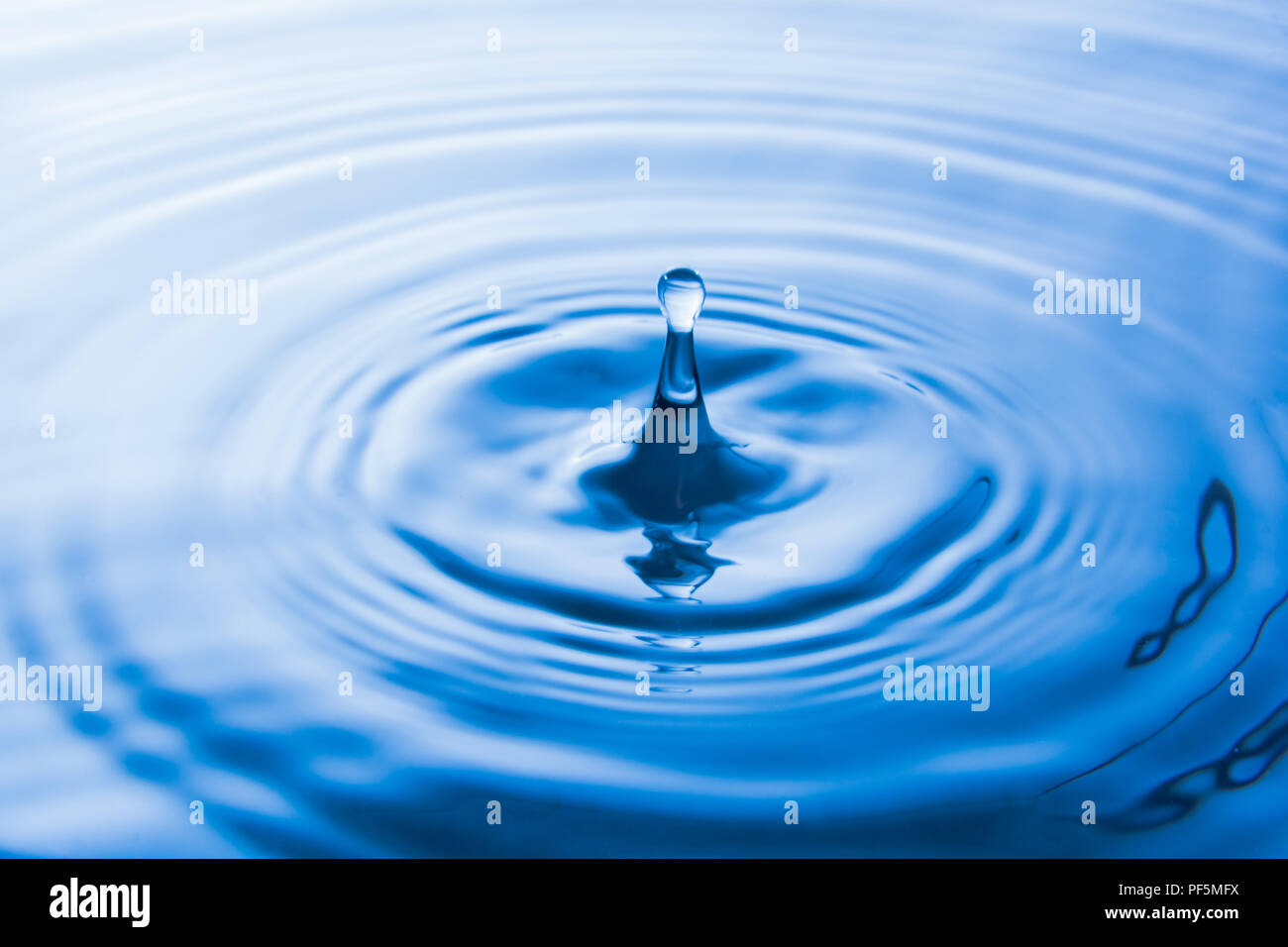 Water drop falling into water make waves. Water splash or water drop ...