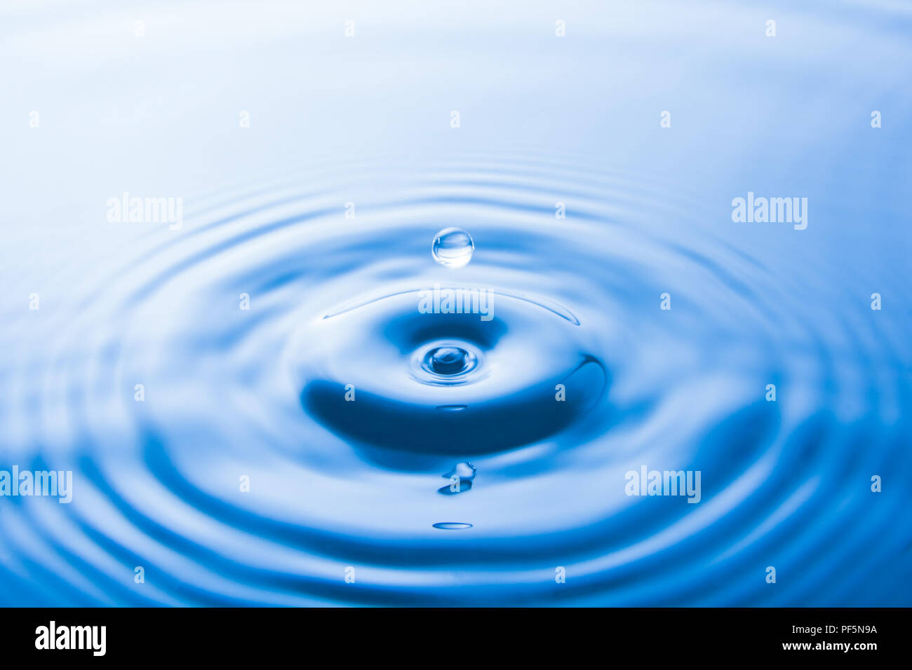 Water drop falling into water make waves. Water splash or water drop ...