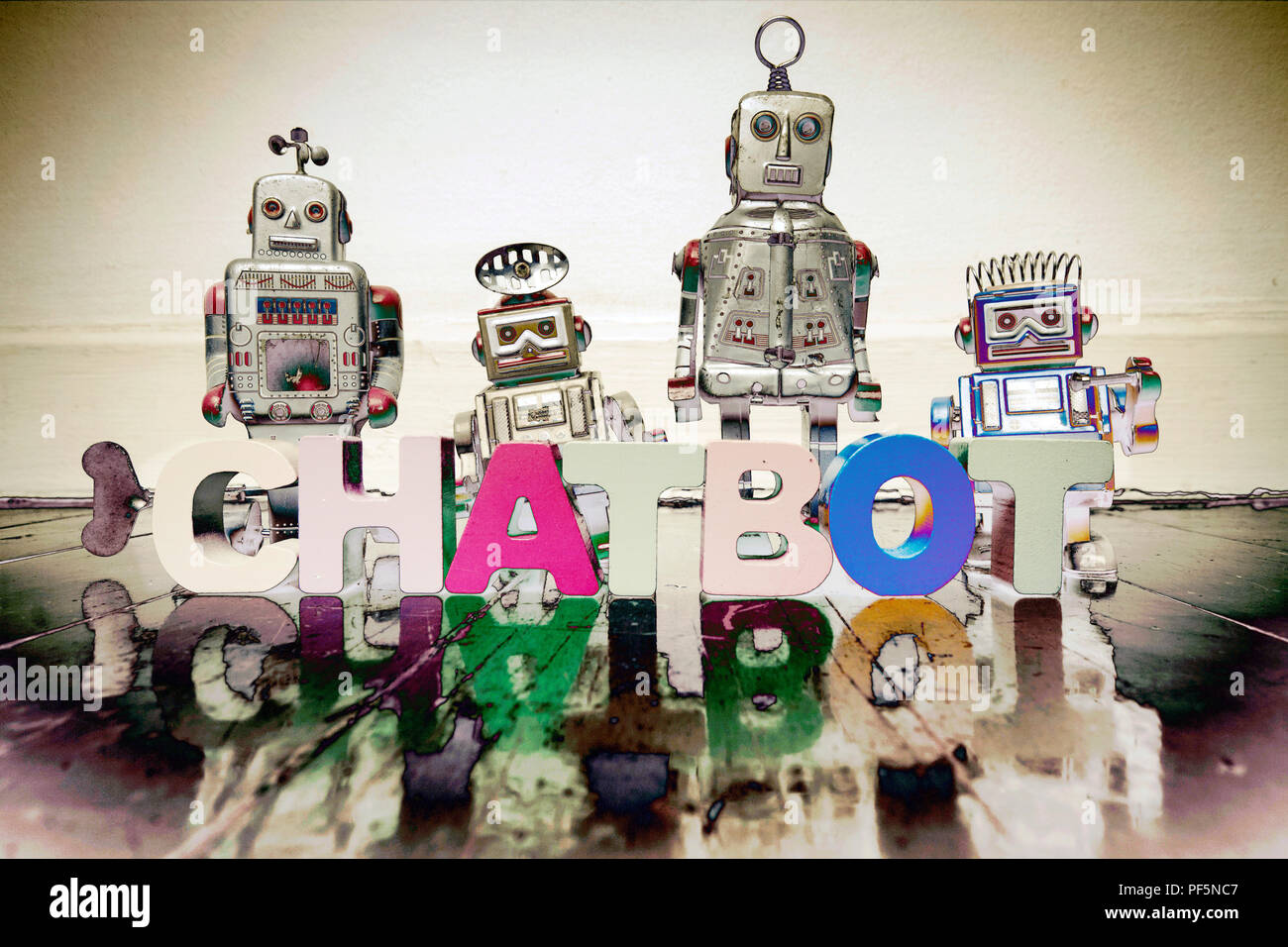 the word CHAT BOT with wooden letters and retro toy robots on an old ...