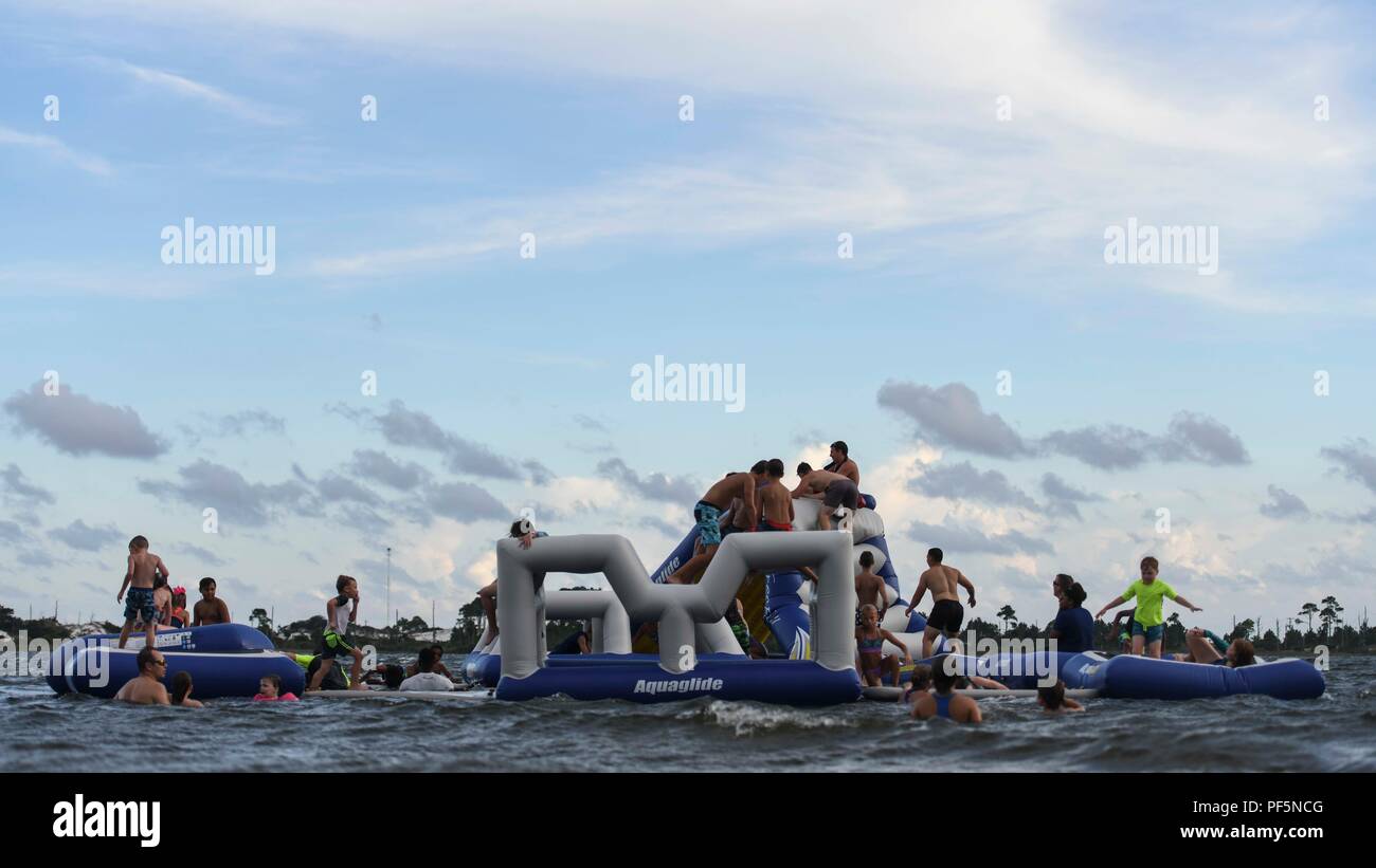 Air Commandos and families play on an inflatable water park during ...