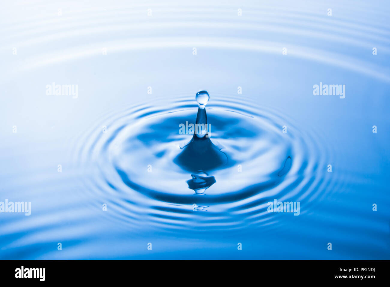 Water drop falling into water make waves. Water splash or water drop ...