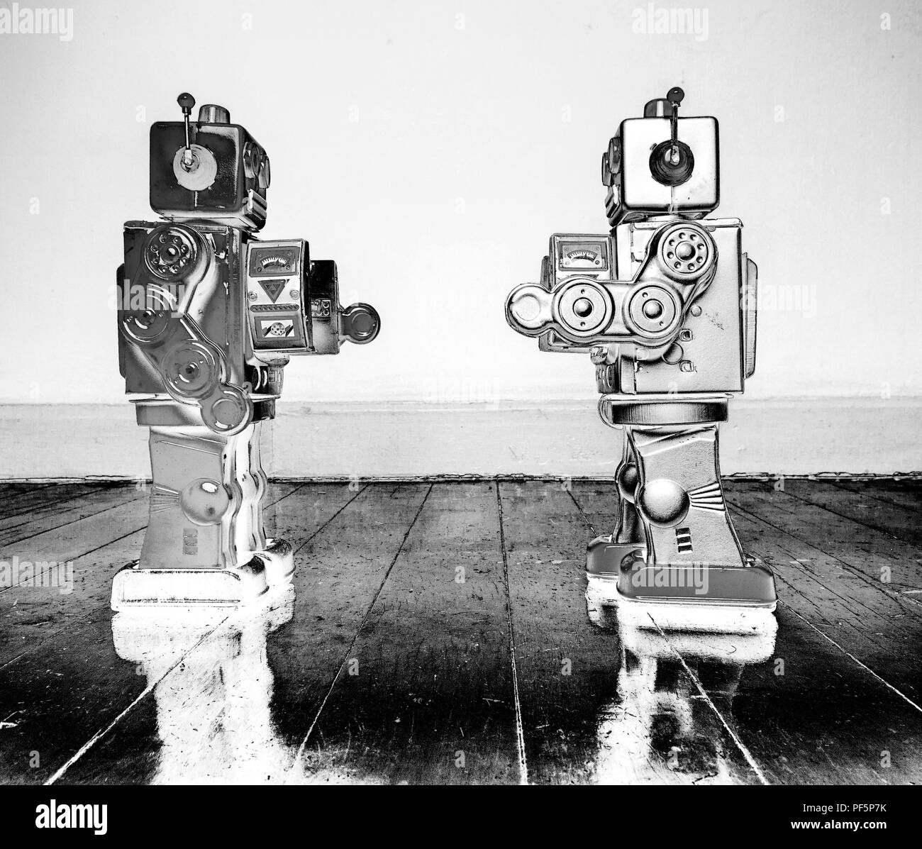 two retro robots face off with ray guns on a wooden floor with ...