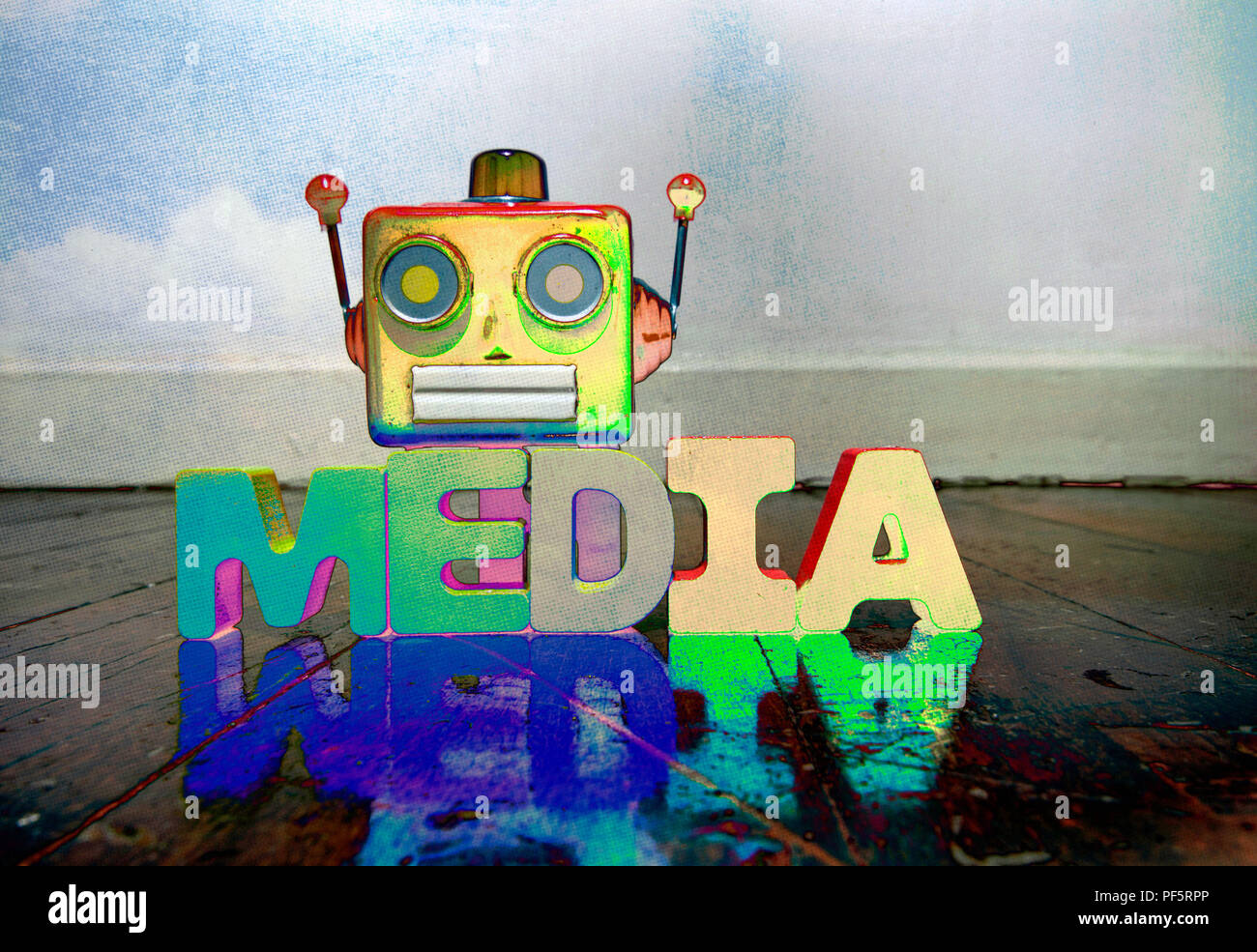 red robot head on wooden letters that say MEDIA on an old wooden floor ...