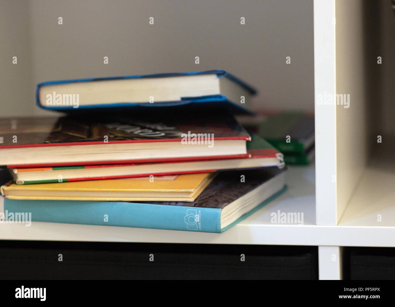The White Bookshelf and several books lying in disarray Stock Photo - Alamy