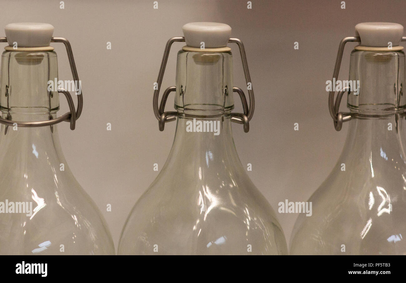 Three empty glass bottles standing in a row Stock Photo - Alamy