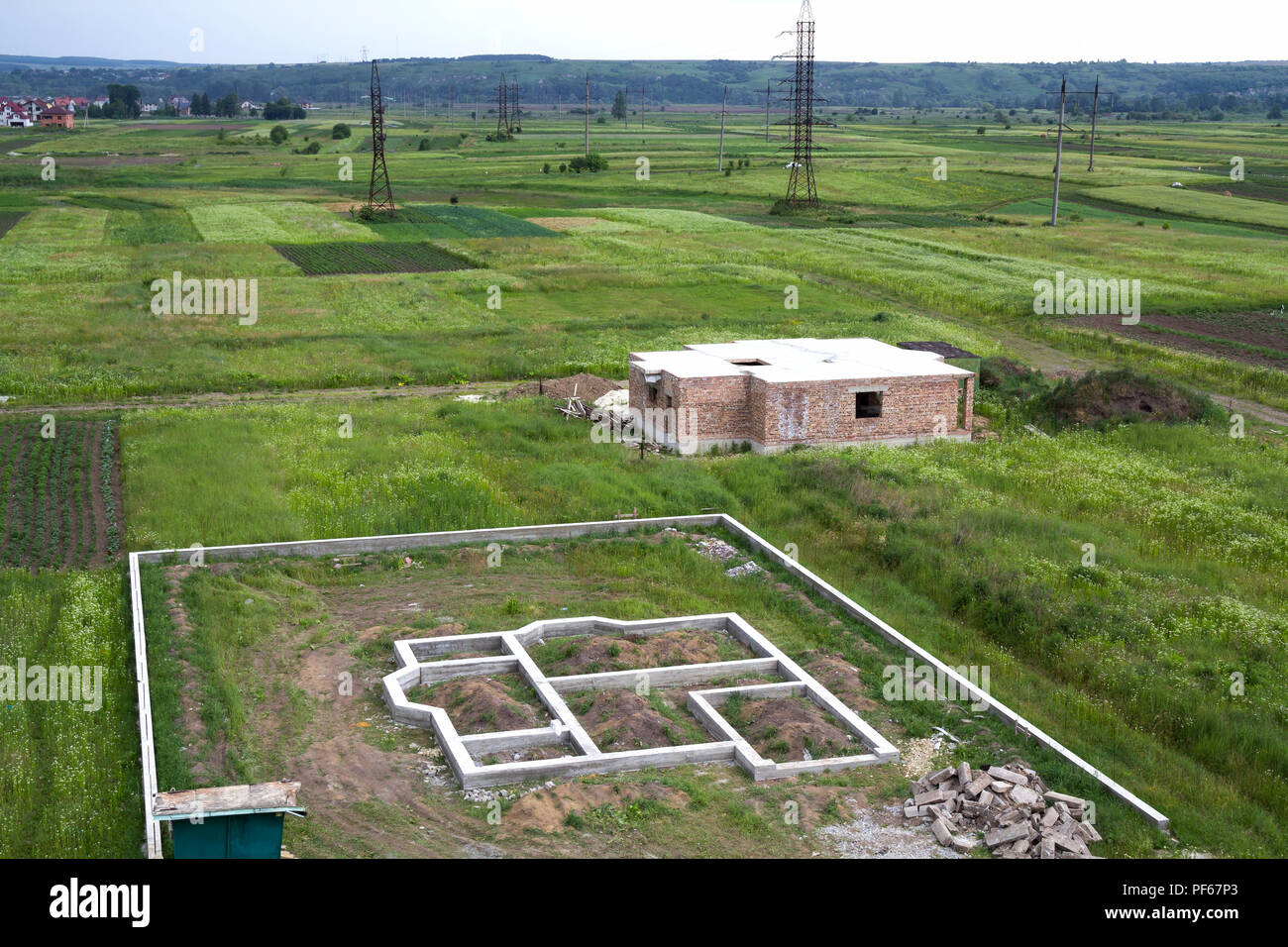 Building site in green field. Trenches dug in ground and filled with ...