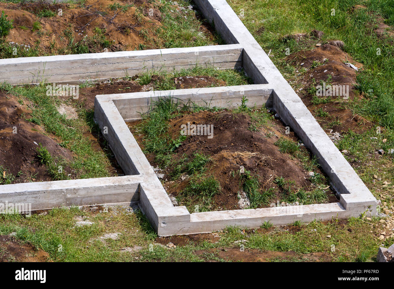 Building site in green field. Close-up detail of trenches dug in ground ...