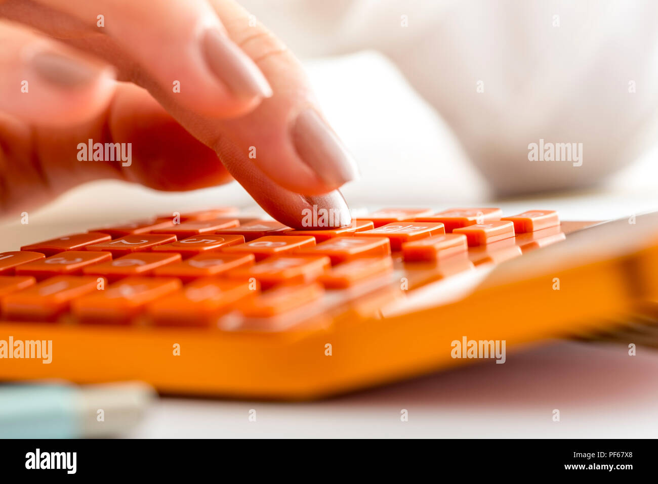Closeup of female accountant or banker making calculations on orange ...