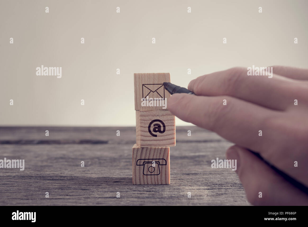 Retro effect faded and toned image of a man drawing contact symbols ...