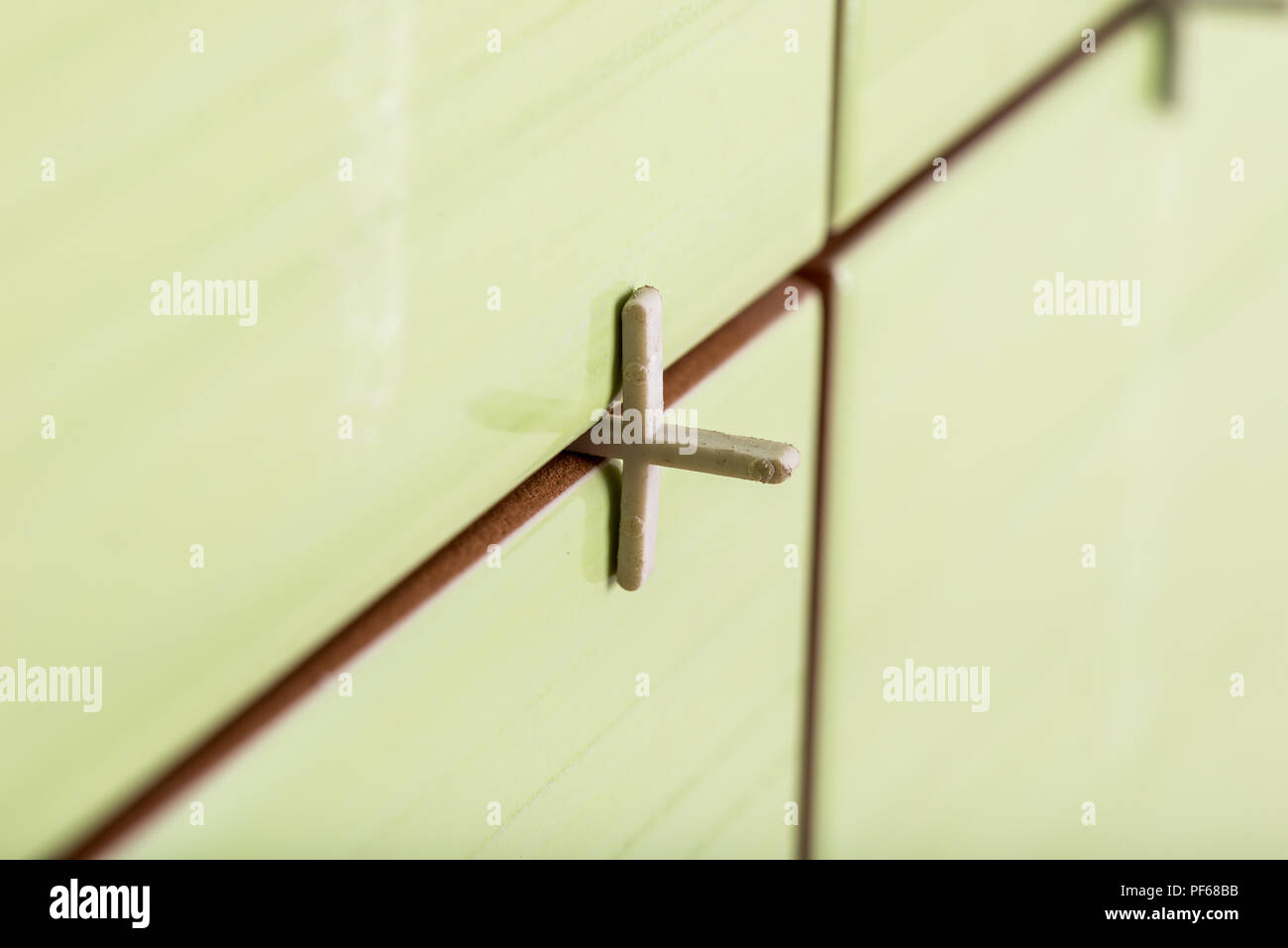 Closeup of unfinished green ceramic tiles with tile spacers. Concept of ...