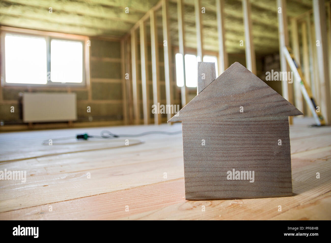 Close-up of simple small brown model house on blurred building tools ...