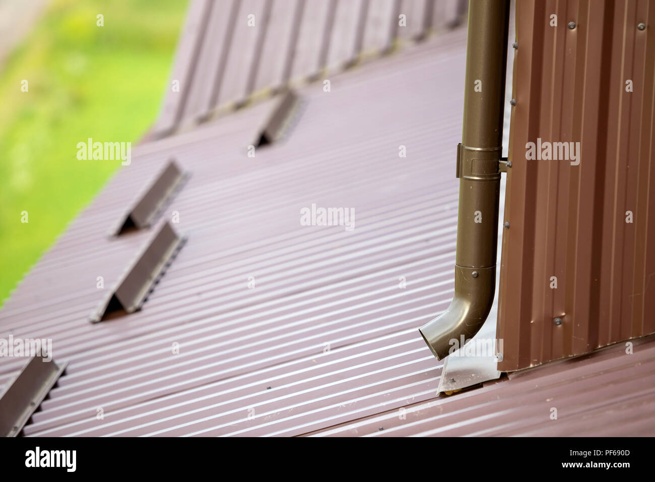 Close-up of brown new gutter metal system pipe on blurred copy space ...