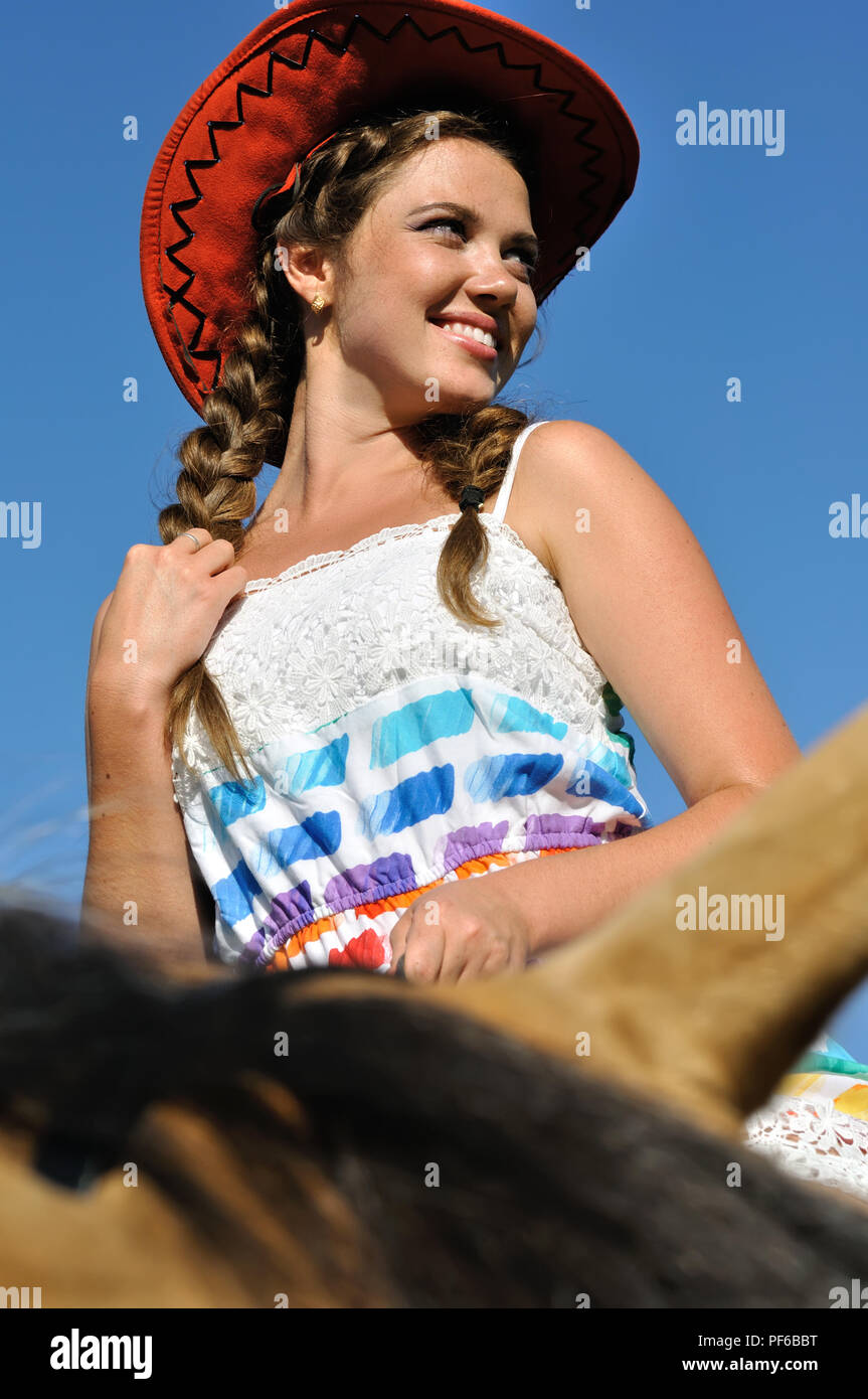 young attractive woman horseback riding in sunny day, vertical ...