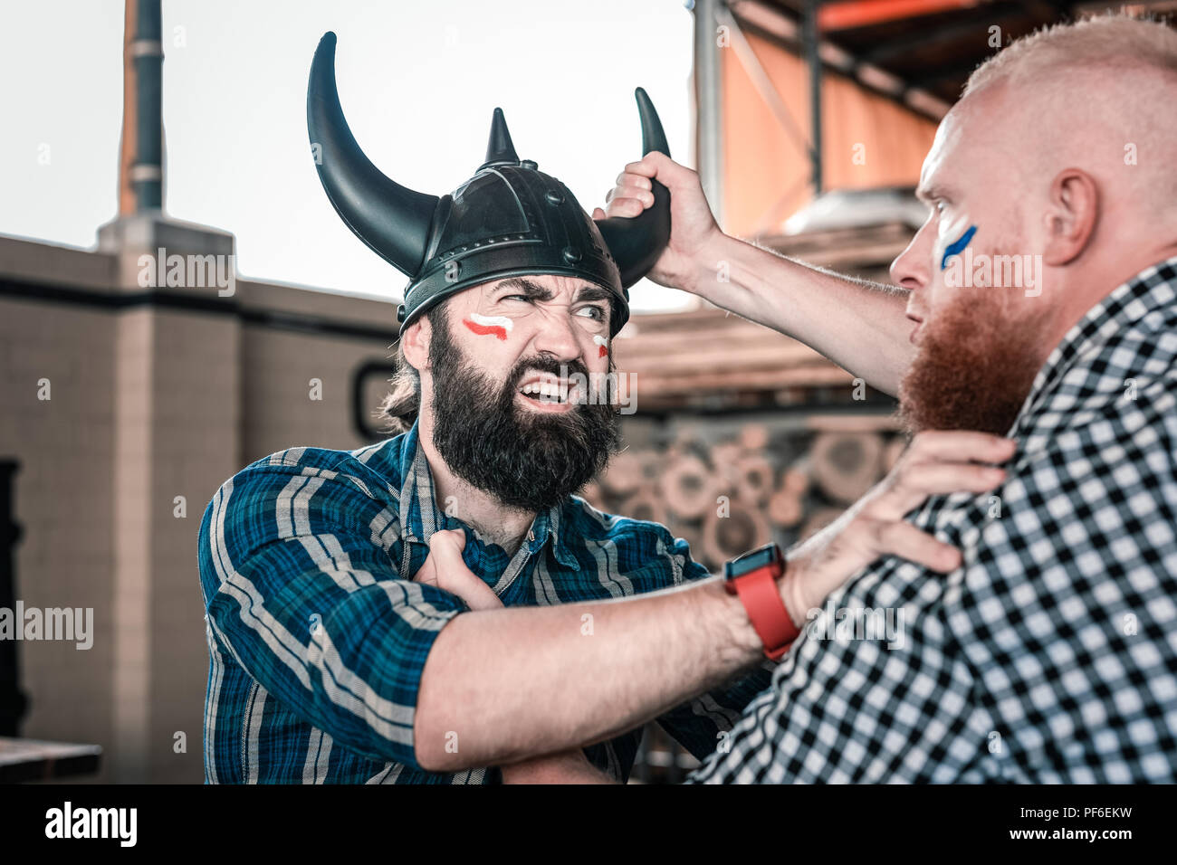 Crazy red-haired football fan beating man sitting in the pub Stock ...