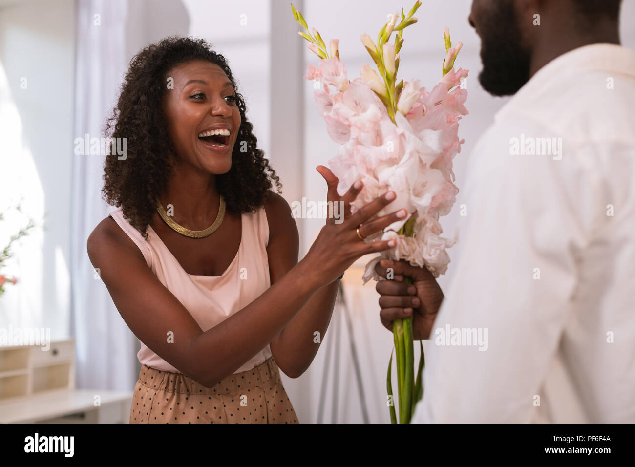 Delighted beautiful woman receiving flowers from husband Stock Photo ...