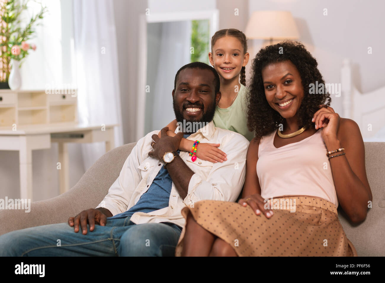 Joyful happy girl standing behind her parents Stock Photo - Alamy