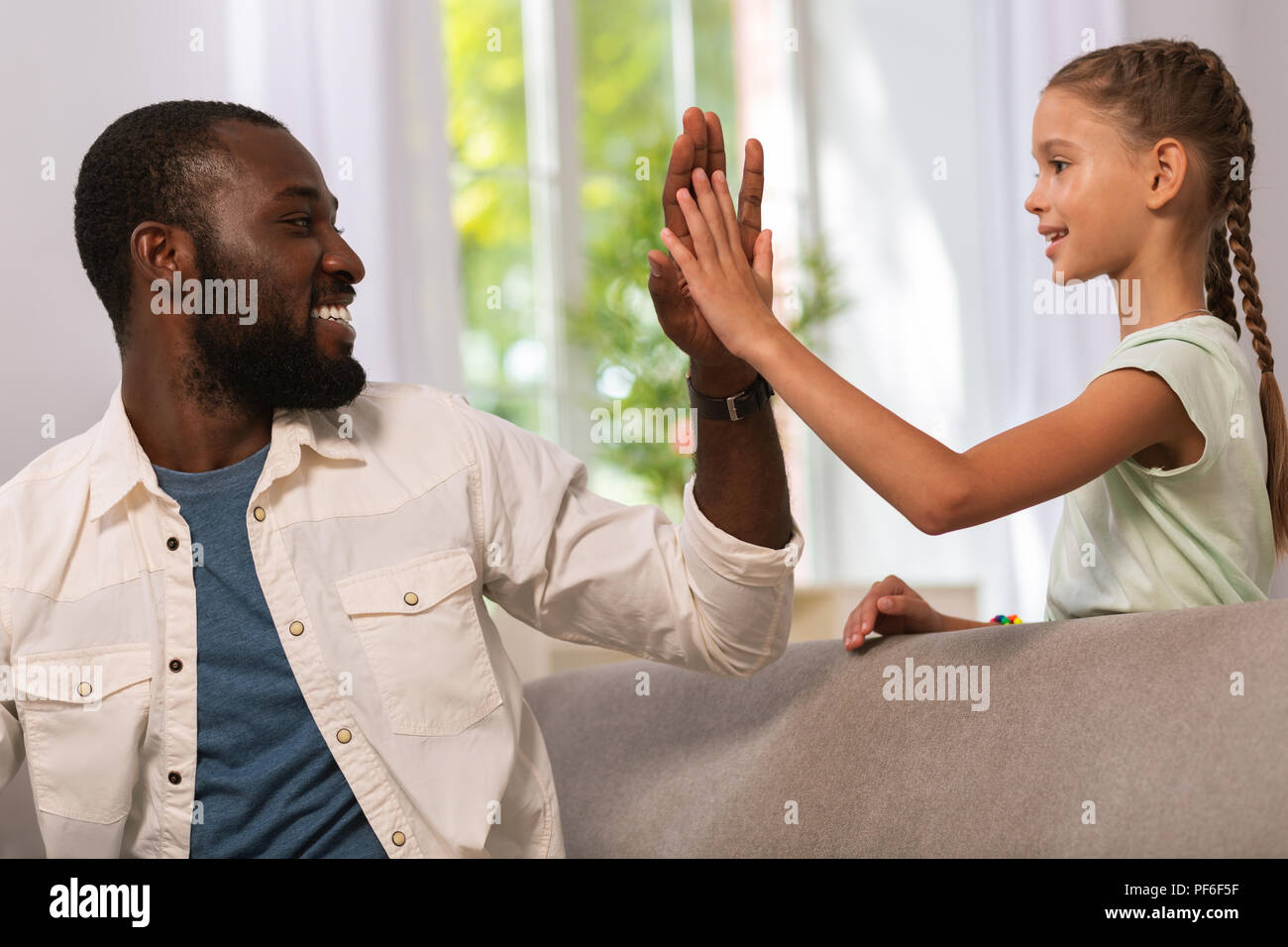 Joyful happy father and daughter giving high five Stock Photo - Alamy