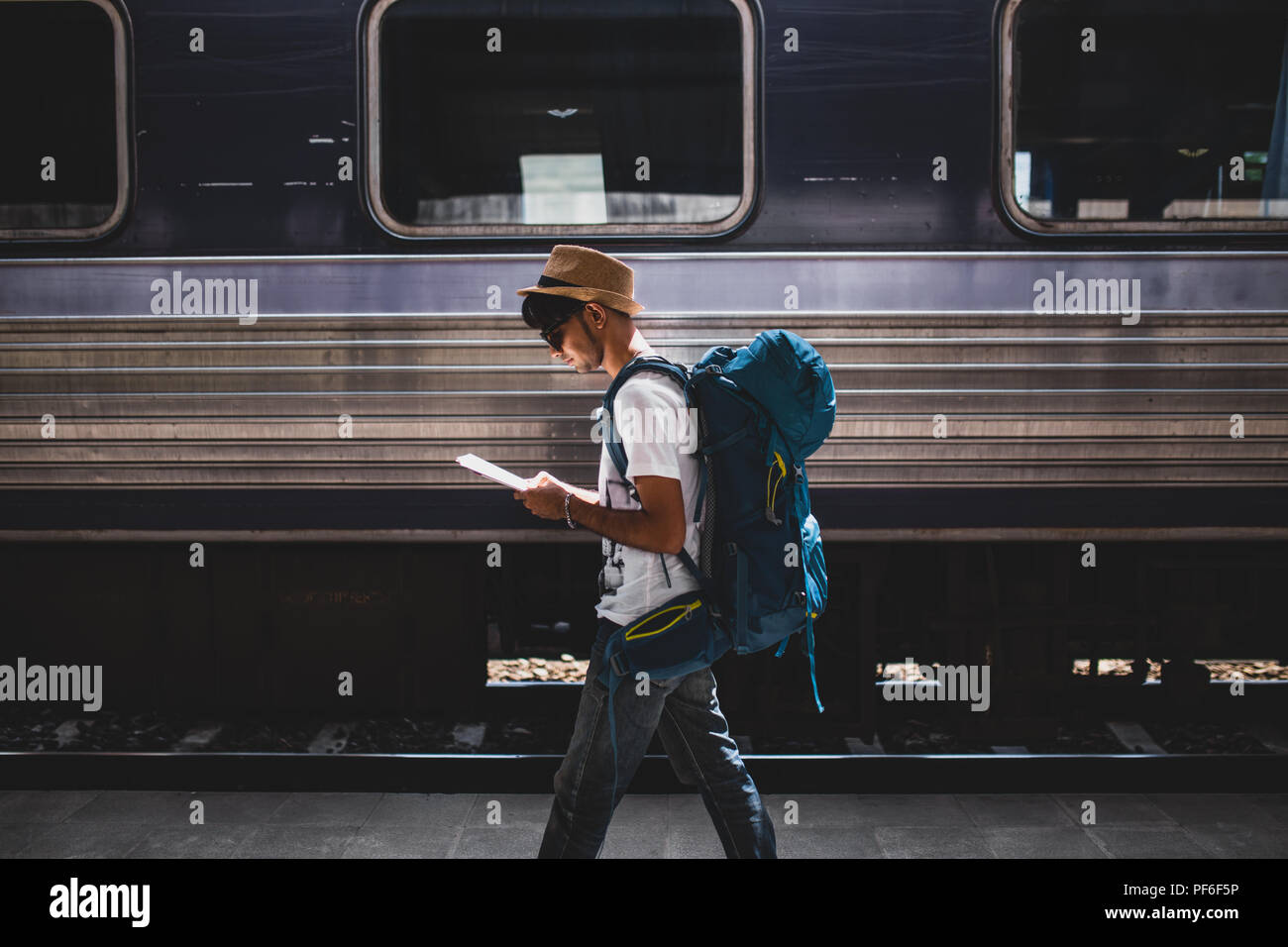 Traveler are backpacking and walking alone at train station Stock Photo ...