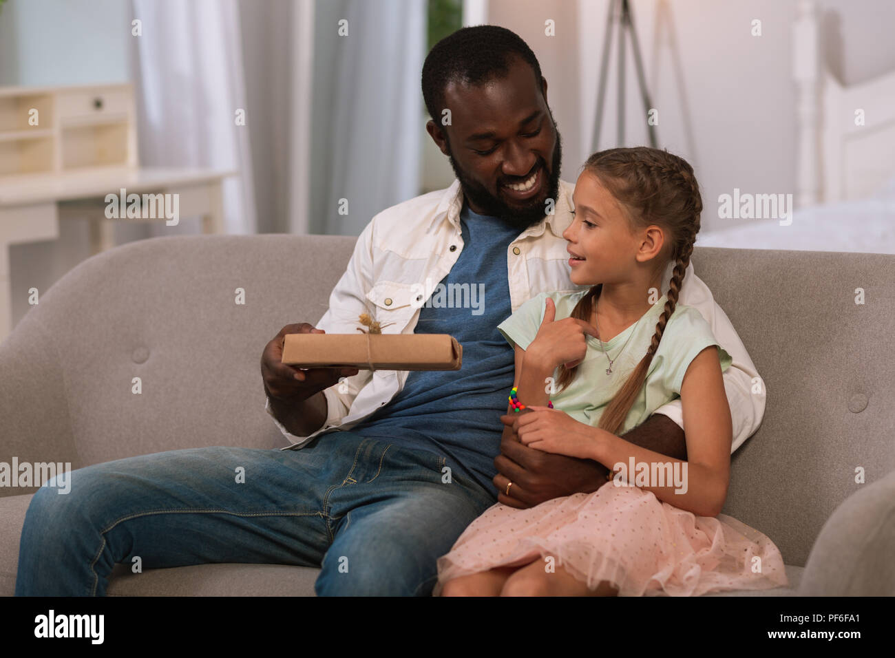 Positive happy man giving a present to his daughter Stock Photo - Alamy