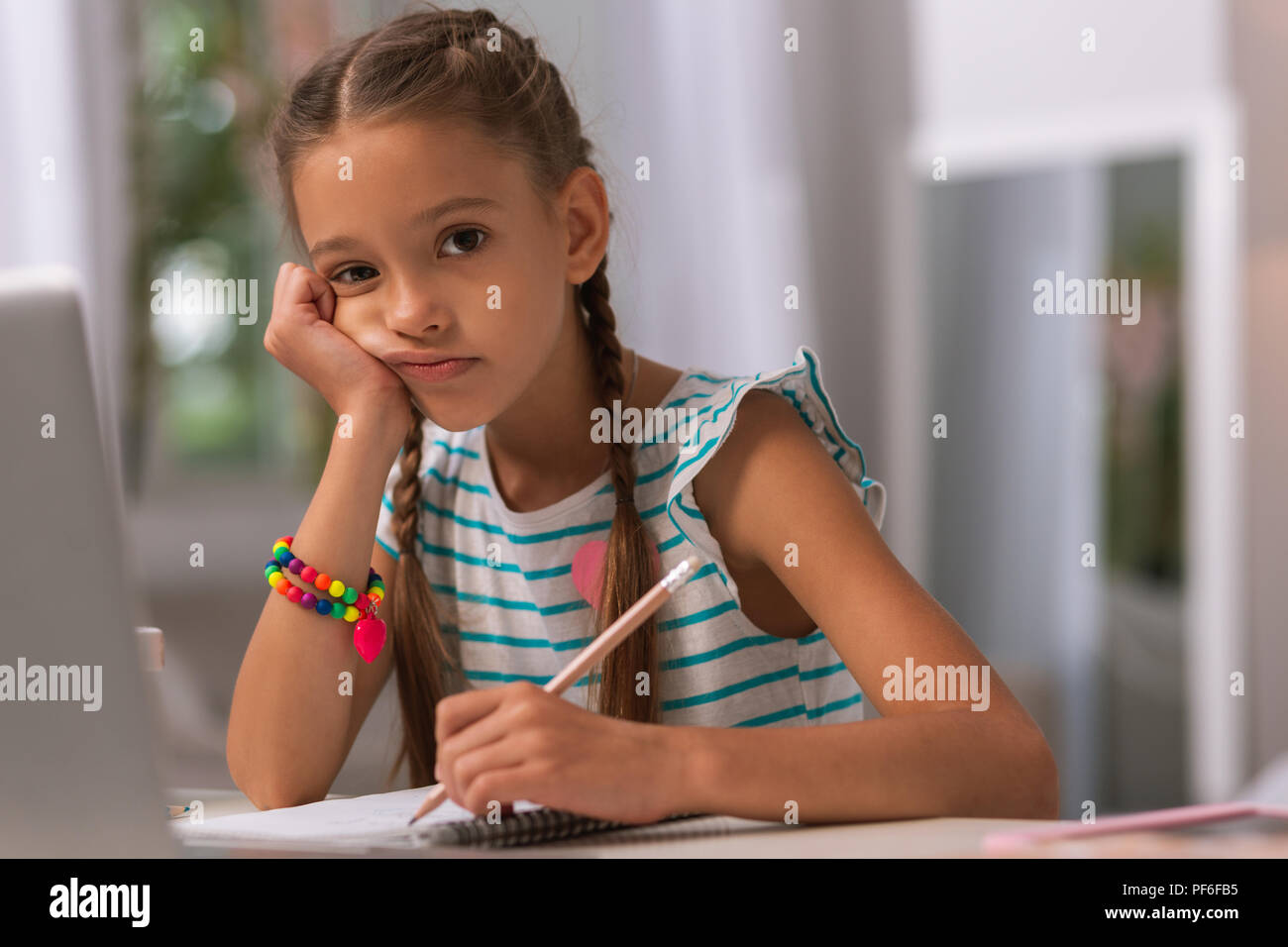 Sad nice little girl holding a pencil Stock Photo - Alamy