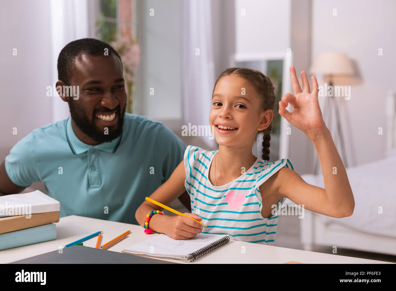 Positive nice girl showing OK sign at home Stock Photo - Alamy