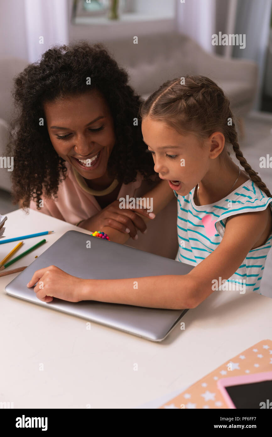 Nice excited girl looking at the laptop Stock Photo - Alamy