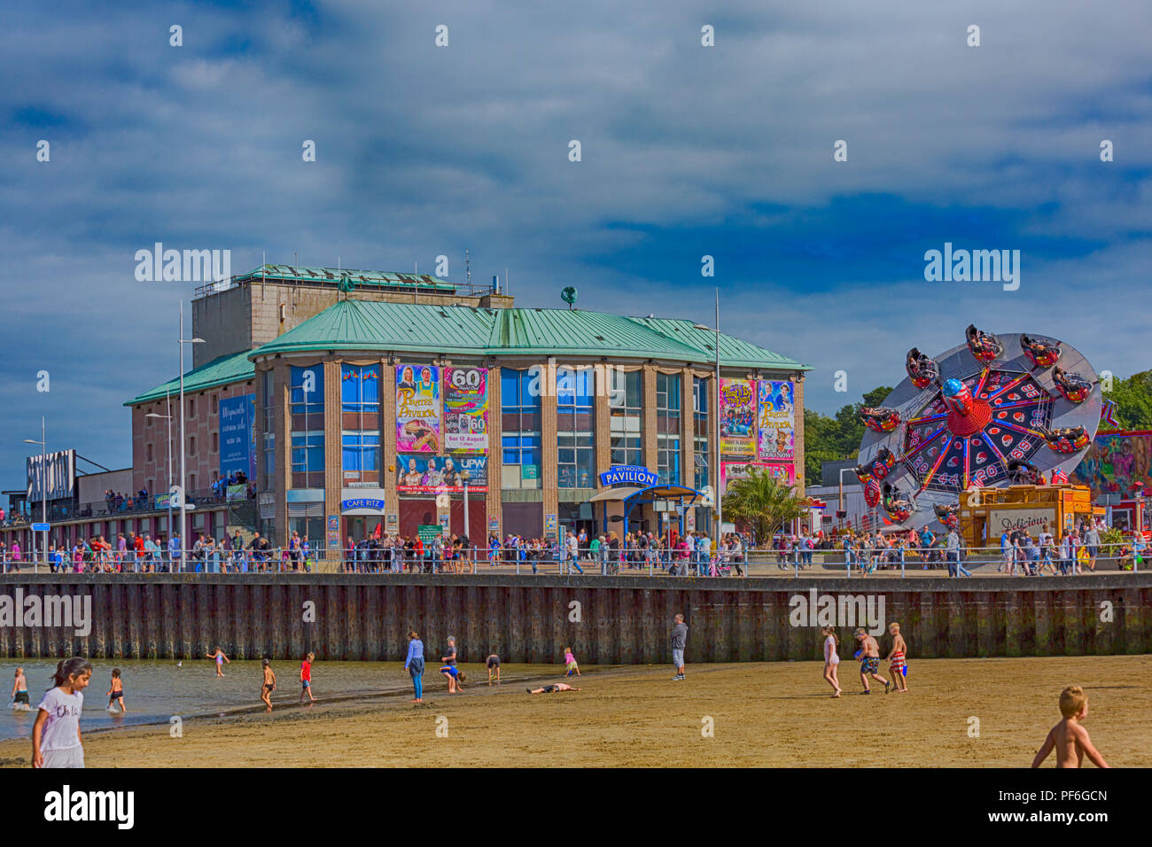 Weymouth Pavilion, beach and fairground ride on a warm sunny day for ...
