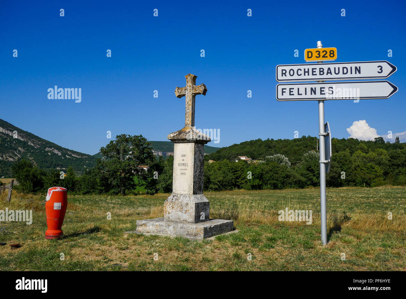 Typical french crossroad with a calvary, a fire hydrant and a road sign ...